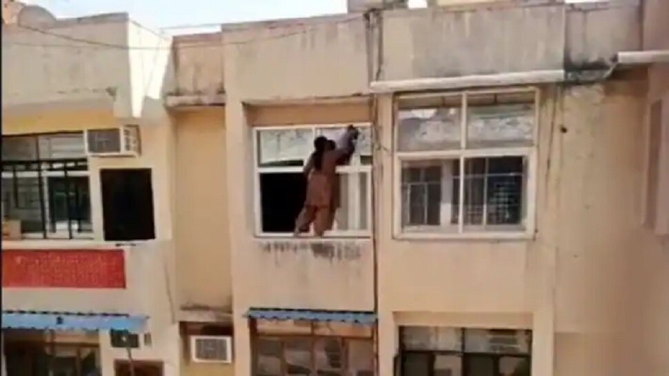 Women seen climbing out of window of her house wiping glass panels from ...